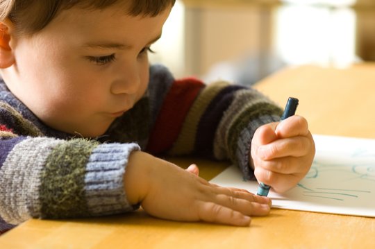 Young child holding a crayon - Scholastic Shop